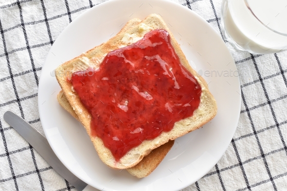 Toast with raspberry jam and butter on a plate. Food from above. Lovely ...