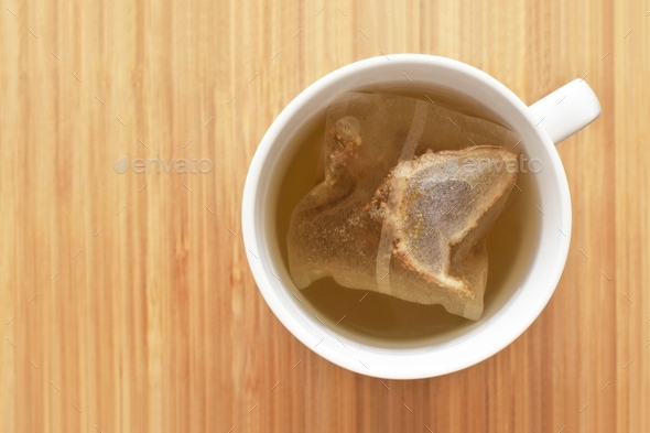 Tea bag in a tea cup. Healthy herbal tea in a mug. Flat lay top view ...