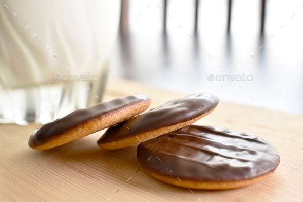 Jaffa cakes with a glass of milk on a bamboo chopping board. Copy space ...