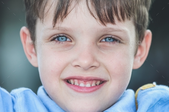 Smiling kid with blue eyes portrait from up-close Stock Photo by dgbdowydas