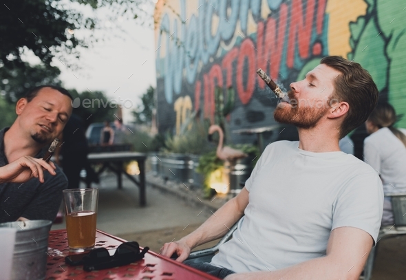 Men at an outdoor bar patio smoking cigars Stock Photo by kytawillets