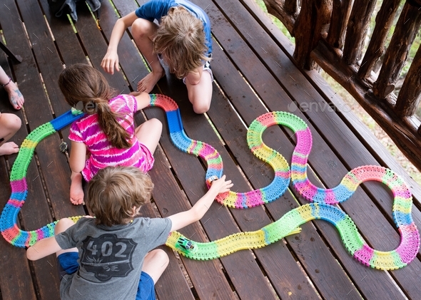 Kids build a car track and play with cars on the colorful track Stock ...