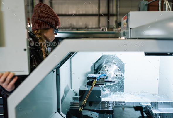 A female machinist operates a lathe in a workshop Stock Photo by ...