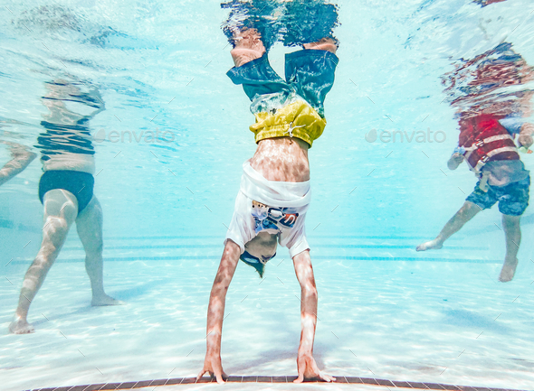 Handstand underwater at the pool while swimming Stock Photo by kytawillets