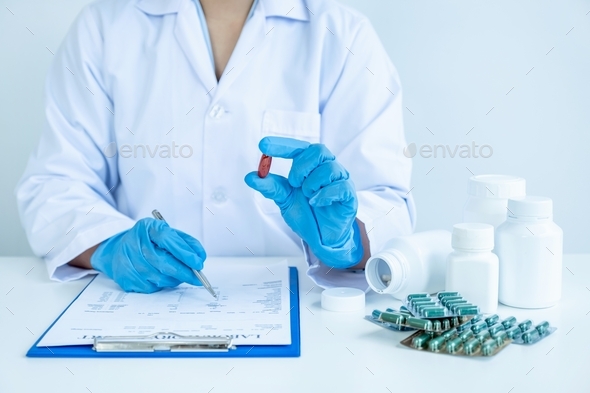 Doctor or nurse hand holding medicine pill and write a prescription at ...