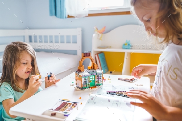 Girls, sisters play kids constructor, build house Lego Harry Potter ...