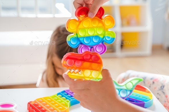 Little girl,kid,child plays with colorful pop it children's room ...