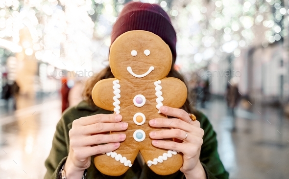 Young beautiful girl, woman with huge funny gingerbread man. Christmas ...