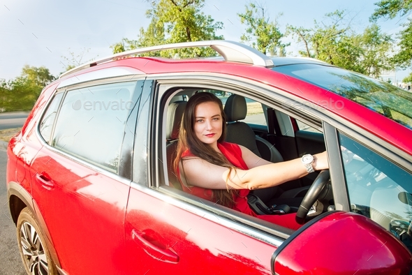 Driving woman in a car. Portrait of a caucasian lady sitting behind ...