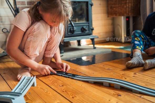 Girls, sisters play kids constructor, build toy railway, railroad by ...