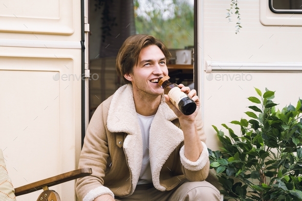 Young stylish american guy,man drinking beer,traveling in camper,house ...