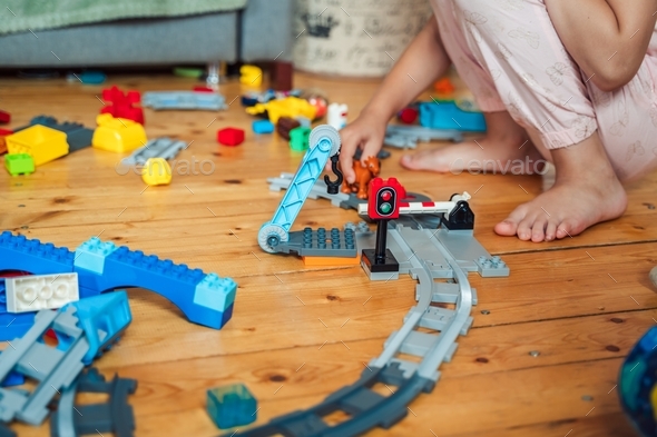 Girls, sisters play kids constructor, build toy railway, railroad by ...