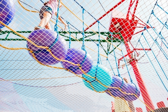 Small children have fun in rope amusement park. Suspended rides on top ...