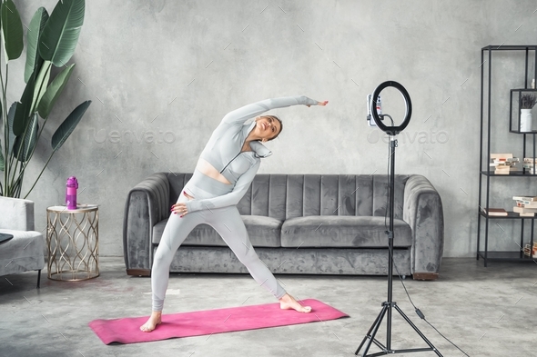 Young sporty slim woman yoga coach, female fitness instructor records ...