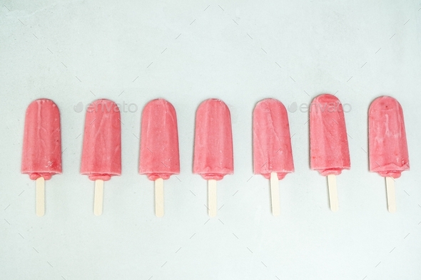 Strawberry flavored pink popsicles in the row. Stock Photo by SmitBruins
