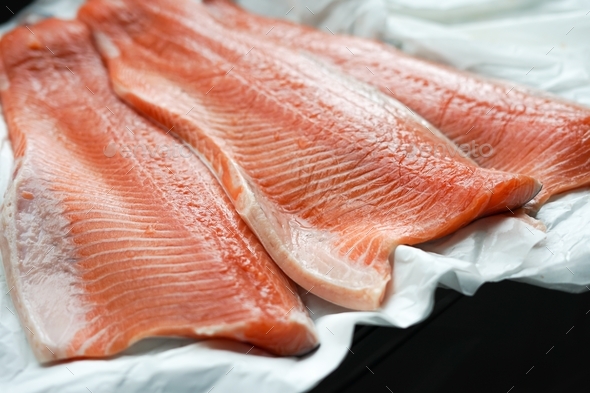 Salmon fillet on the white paper. Uncooked fresh salmon pieces. Stock ...