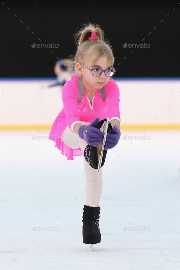 Cute little girl on skating rink. Little figure skater on the ice. Ice ...