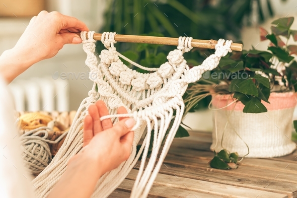 Close up of women's hands weaving macrame in a home workshop.Handmade ...