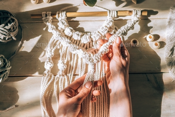 Close up of women's hands weaving macrame in a home workshop,top view ...