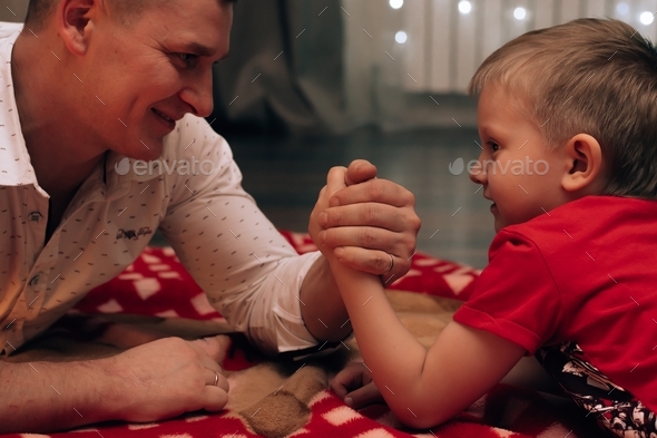 Dad and son are fighting on their hands at home. Stock Photo by ...