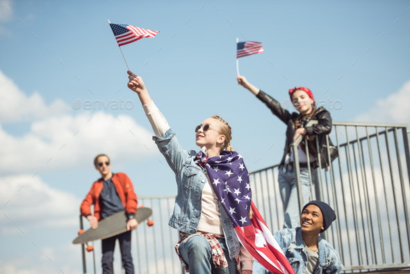 Teenagers group having fun together and waving american flags at ...