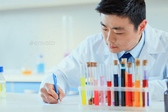 young asian doctor in uniform working at testing laboratory, chemical ...