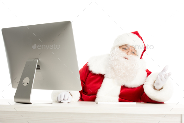 Portrait of Santa Claus using computer and gesturing towards camera by ...