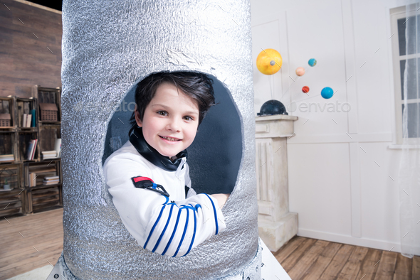 smiling boy in astronaut costume sitting in toy rocket Stock Photo by ...