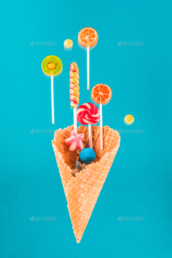 Close-up view of crispy waffle cone with sweet candies and lollipops ...