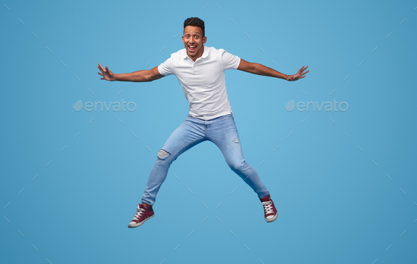 Funny black man jumping and looking at camera Stock Photo by kegfire