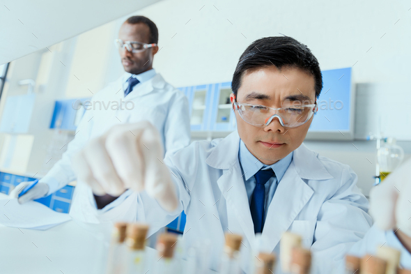 Professional scientists in white coats working together in chemical ...