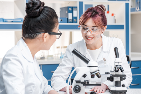 scientists working together with microscopes in chemical lab ...