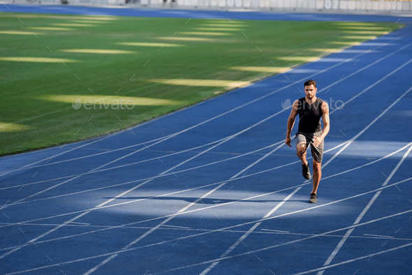 fast handsome runner exercising on running track at stadium Stock Photo ...