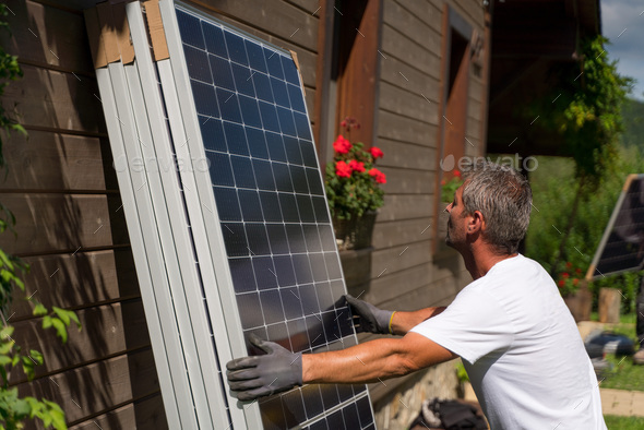 Mature man worker carrying solar panel for installing. Stock Photo by ...