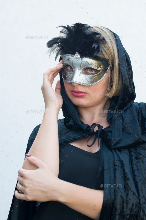 Mysterious Girl in a black cloak and a masquerade mask, visiting a ...