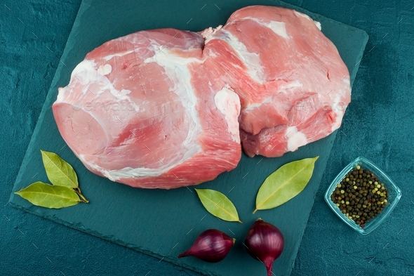 a large piece of fresh blue meat on a slate stone and a black ...