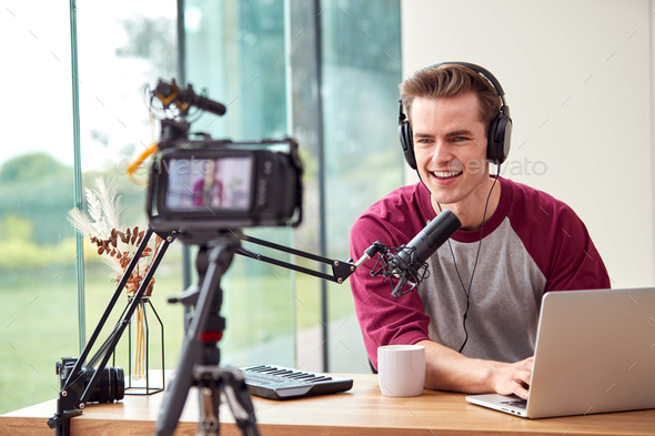 Male Vlogger With Laptop Recording Video At Home With Camera Stock ...