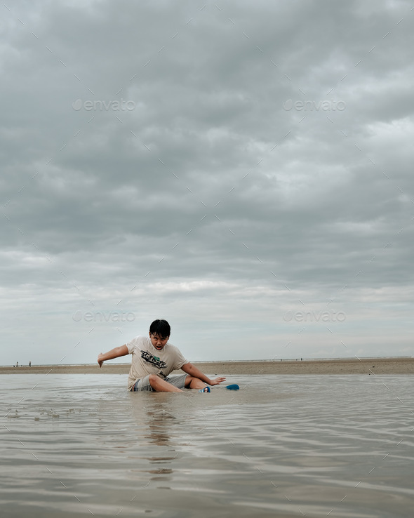 Kid playing in the puddle at the beach during summer Stock Photo by ...