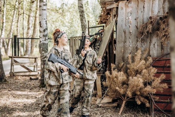 Boy and girl with a weapon in his hand playing laser tag shooting game ...