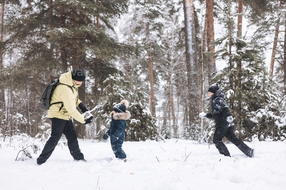 Father and sons having fun snowball fight together Happy children ...