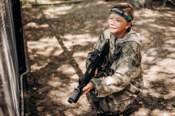 Boy with a weapon in his hand playing laser tag shooting game in ...