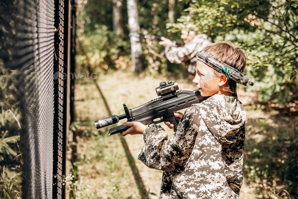 Teenager boy with weapon in his hand playing laser tag shooting game in ...