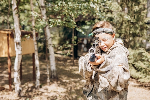 Teenager boy with weapon in his hand playing laser tag shooting game in ...