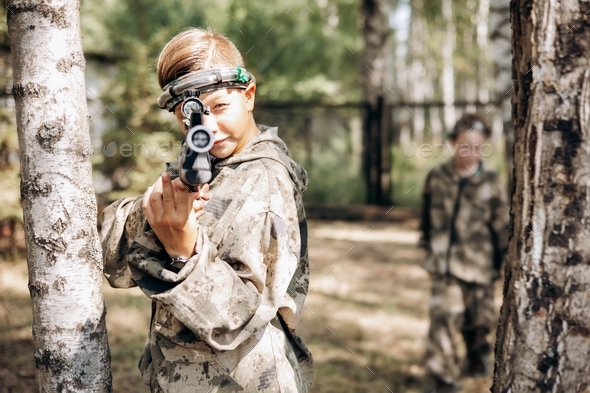 Teenager boy with weapon in his hand playing laser tag shooting game in ...