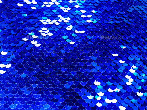 Lots of bright blue sequins sewn on fabric as scales. Beautiful shiny ...