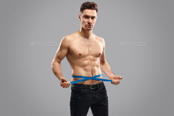 Muscular guy measuring waist Stock Photo by kegfire | PhotoDune