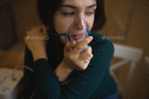 The girl is inhaled at home.Inhaler. Inhalation. Treatment at home ...