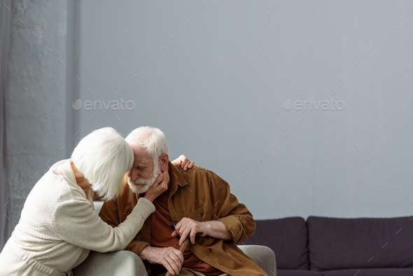 senior woman touching face and hugging husband sick on dementia Stock ...