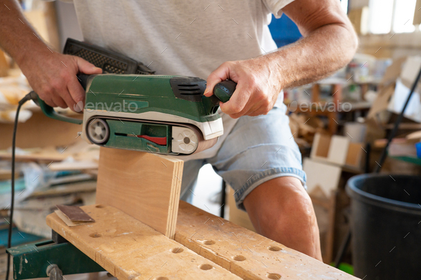 Close up of a carpenter working on wood craft at workspace with ...