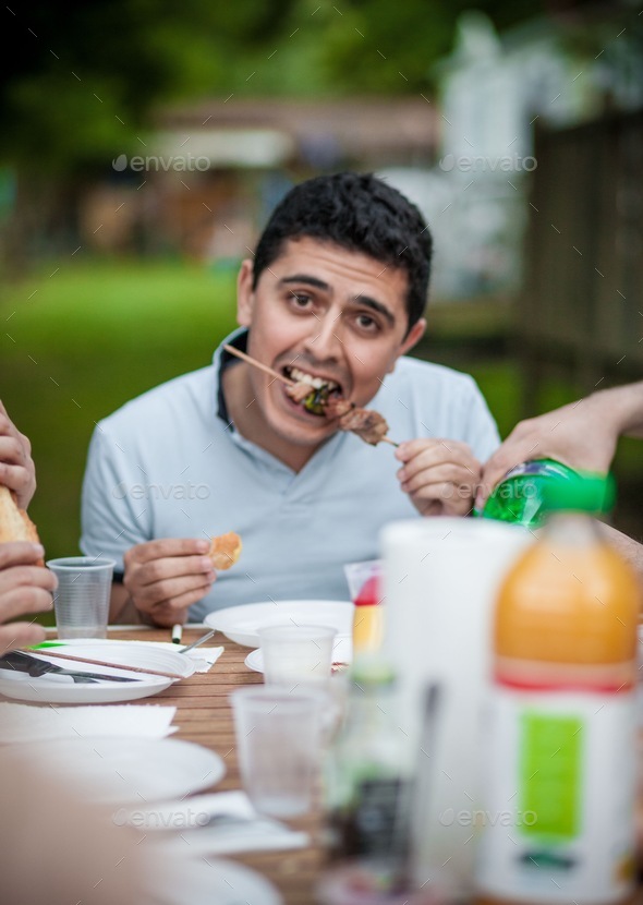 Man eating in a barbecue brunch outside with friends Stock Photo by ...